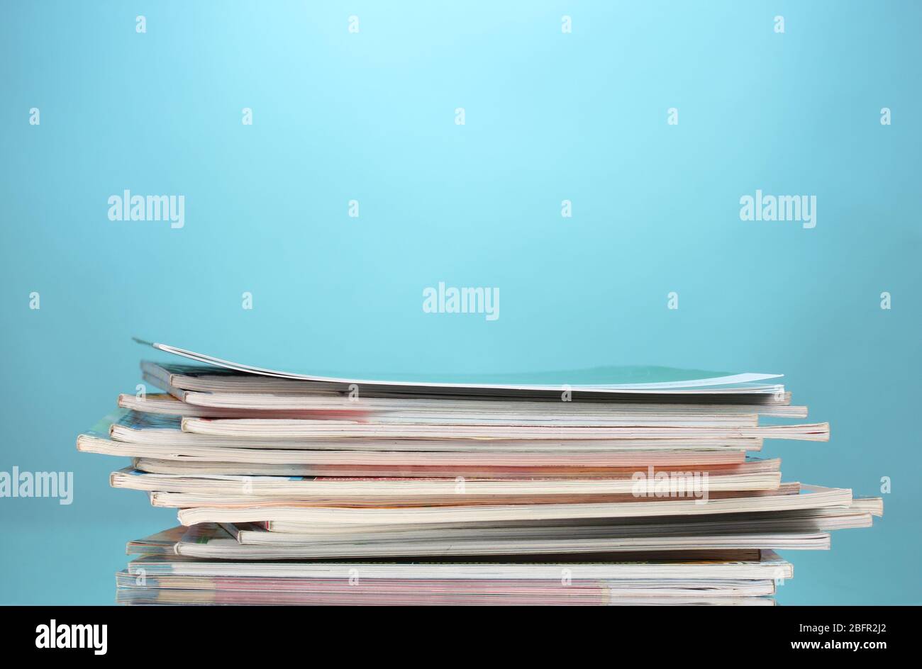 stack of magazines on blue background Stock Photo - Alamy