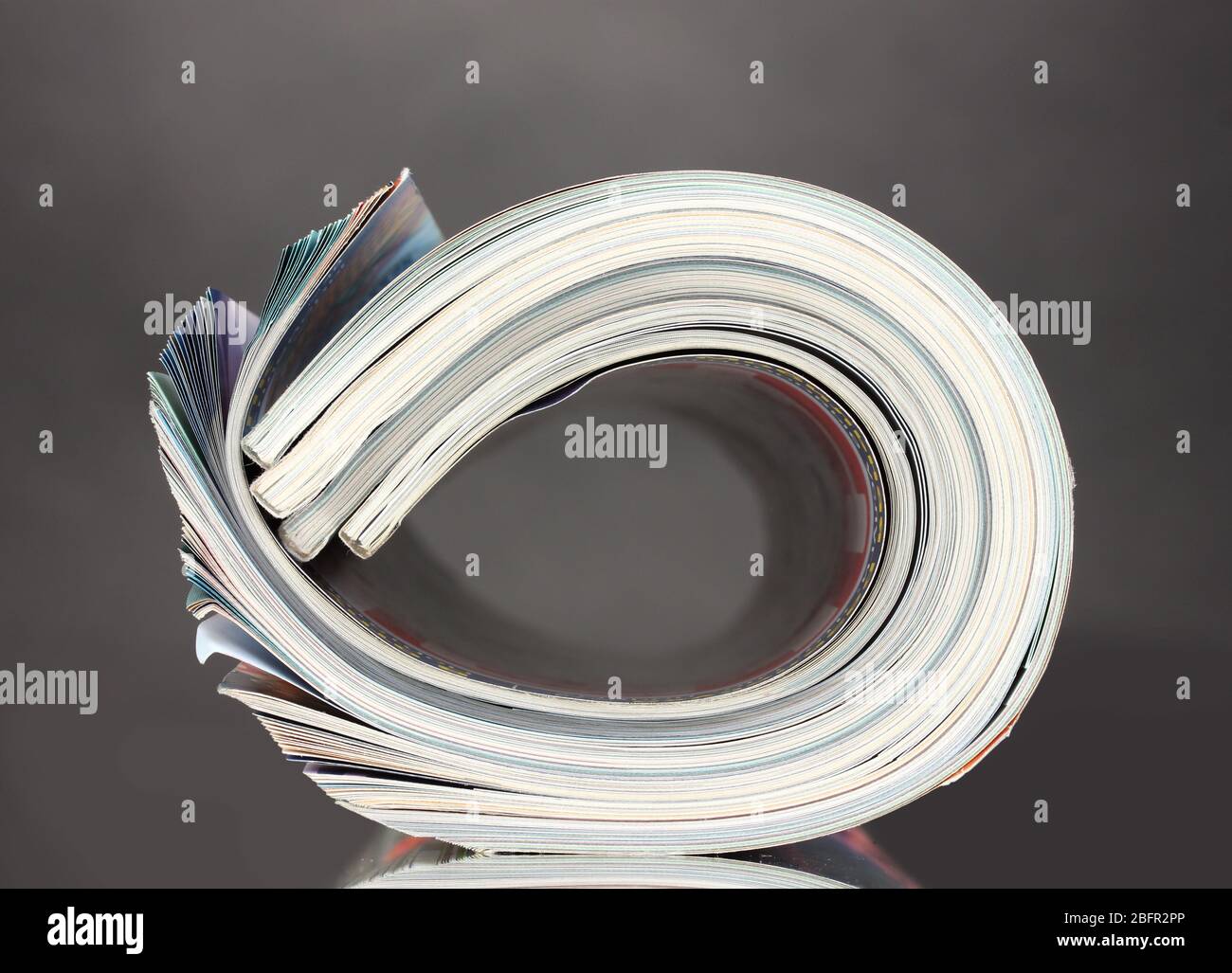 Rolled up magazines on gray background Stock Photo - Alamy