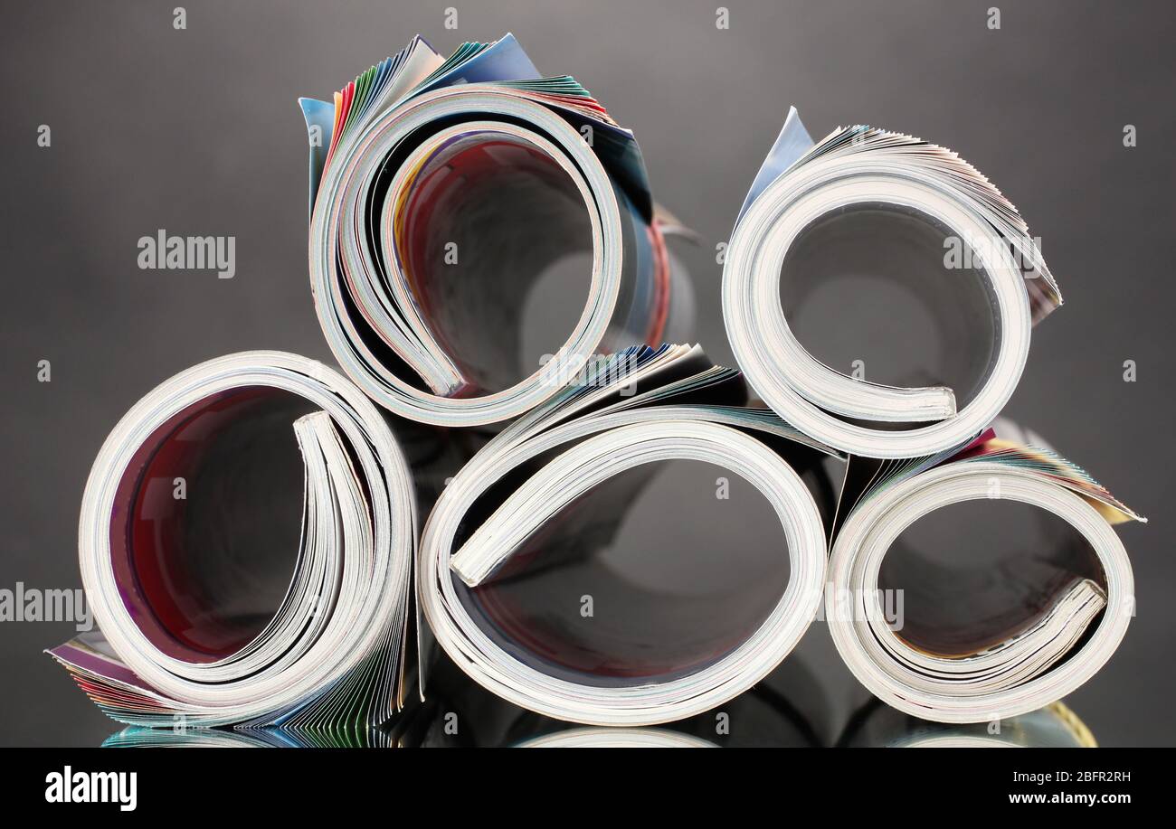 Rolled up magazines on gray background Stock Photo - Alamy