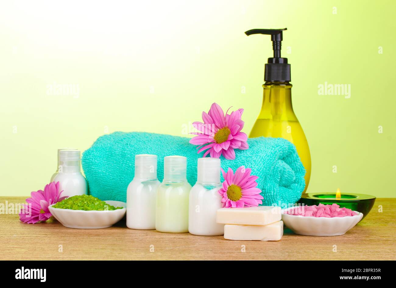 Hotel amenities kit on wooden table on green background Stock Photo - Alamy