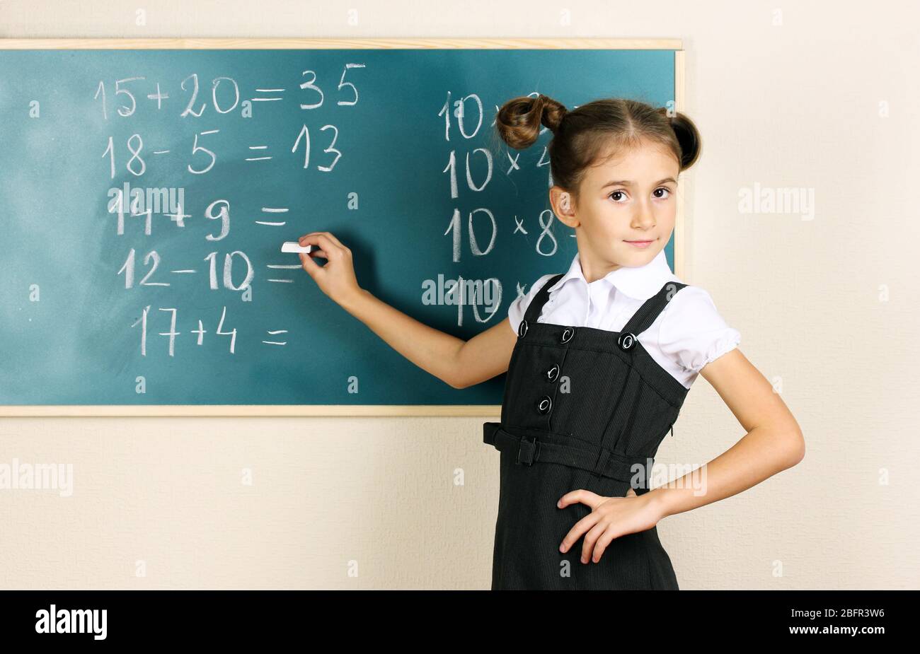 beautiful little girl writing on classroom board Stock Photo - Alamy