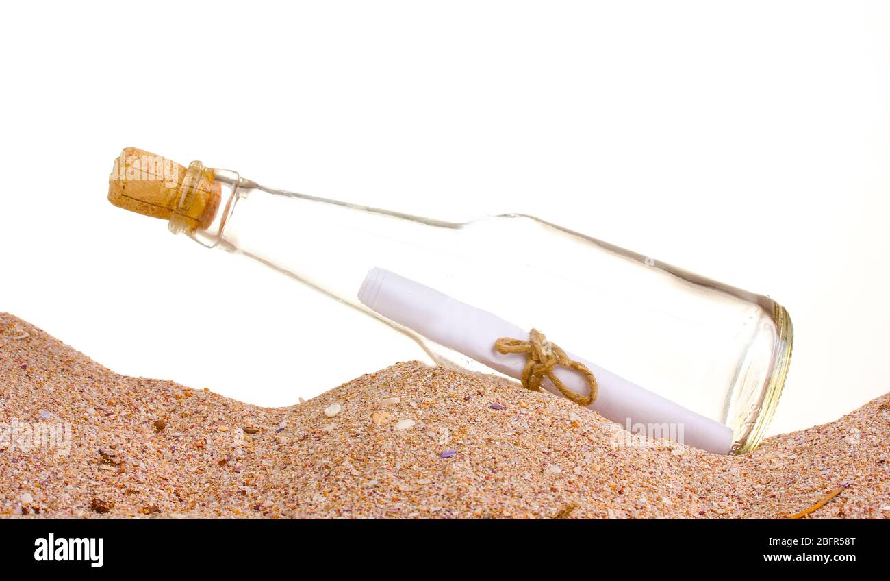 Glass bottle with note inside on sand on white background Stock Photo ...