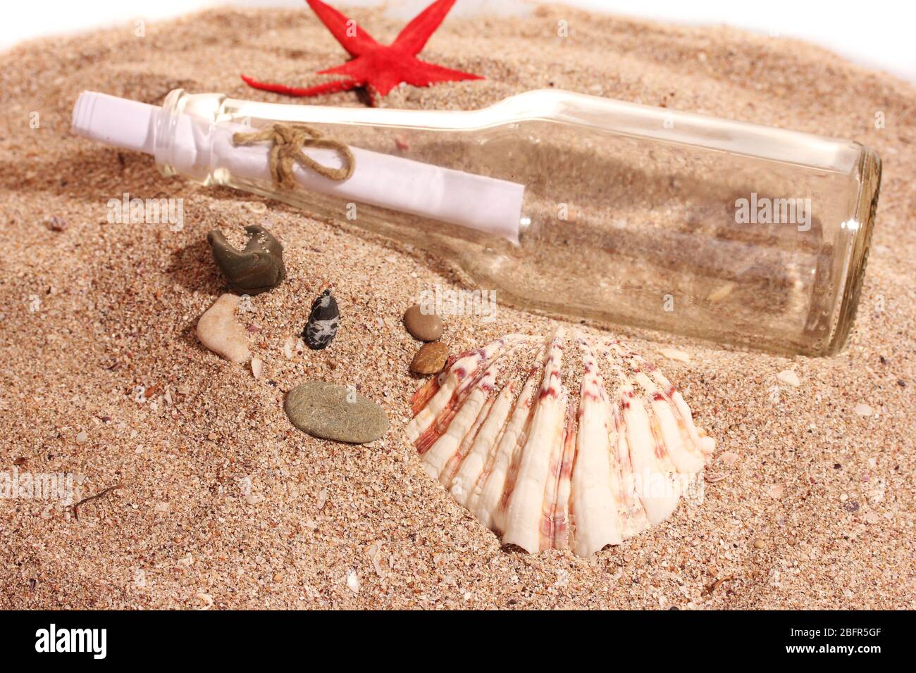 Glass bottle with note on sand shore with seashells Stock Photo - Alamy