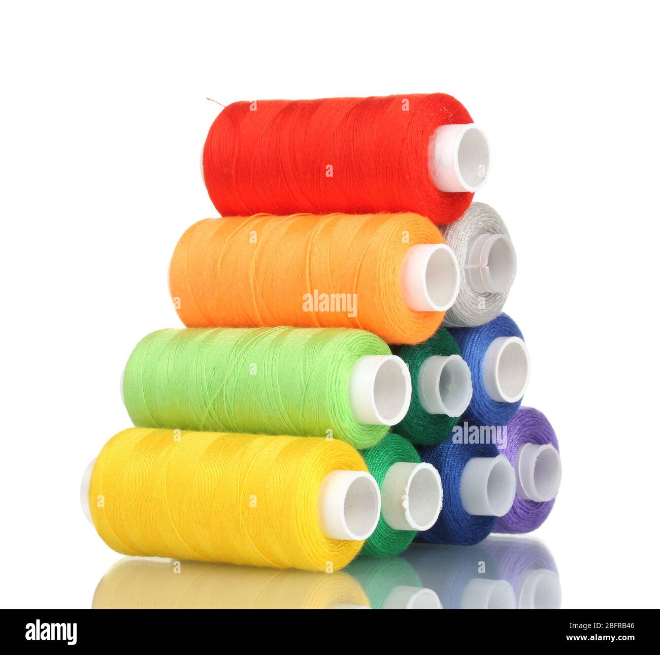 Pyramid of many-coloured bobbins of thread isolated on white Stock ...