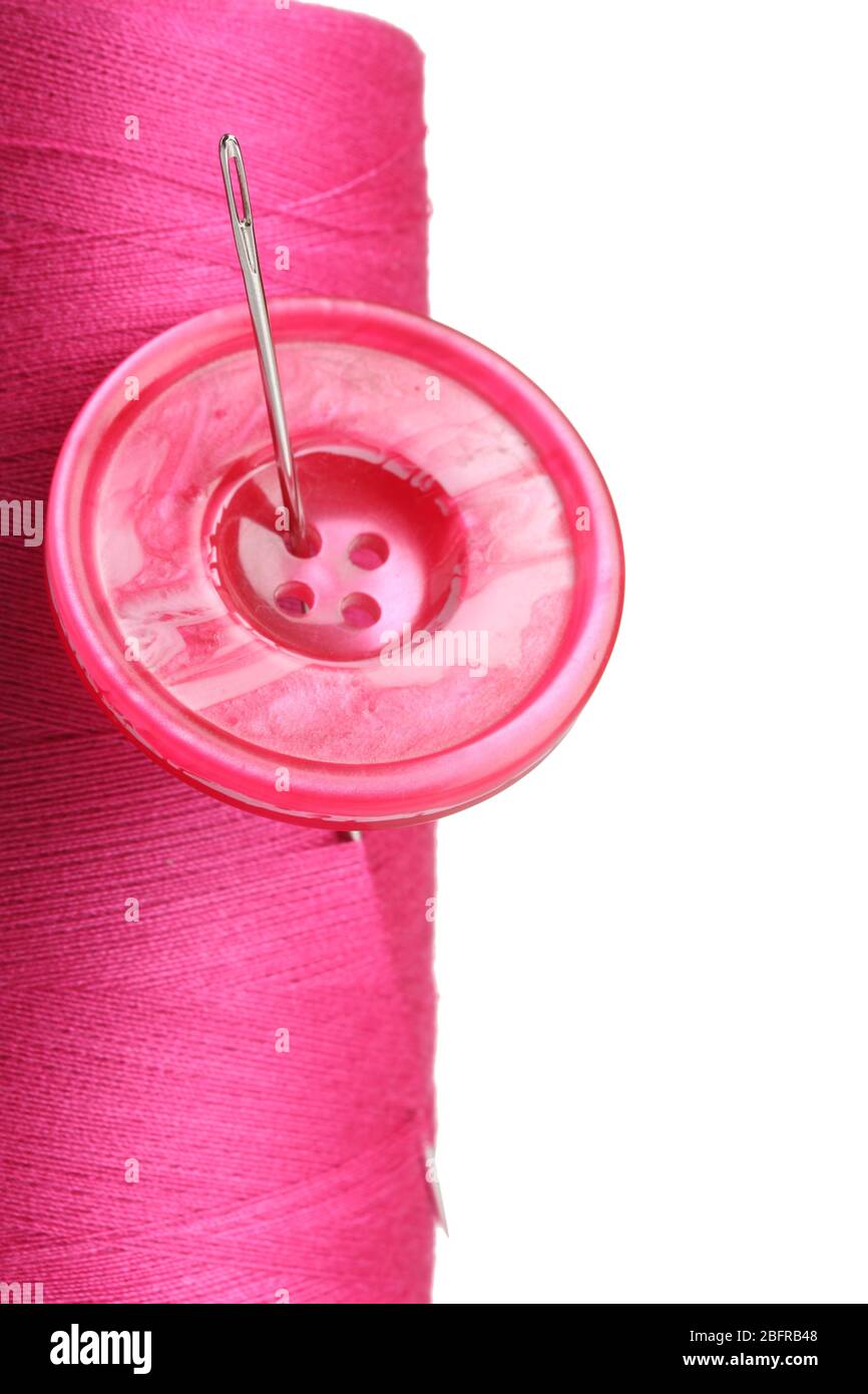 Pink bobbin thread with needle and pink button isolated on white Stock ...
