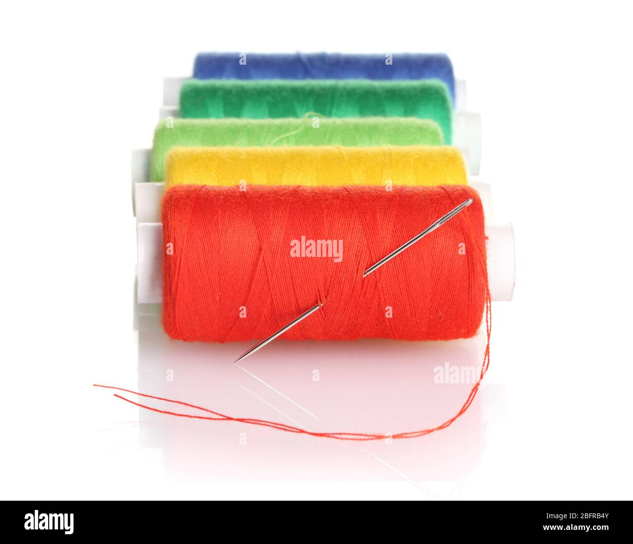 Bobbins of thread with needle isolated on white Stock Photo - Alamy