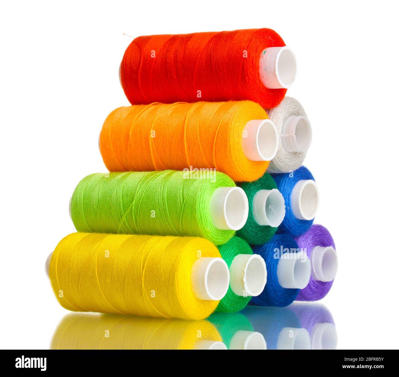 Pyramid of many-coloured bobbins of thread isolated on white Stock ...