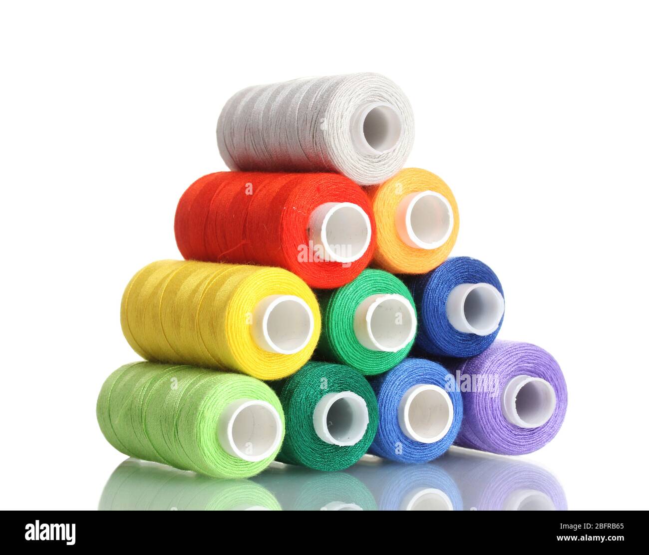 Pyramid of many-coloured bobbins of thread isolated on white Stock ...