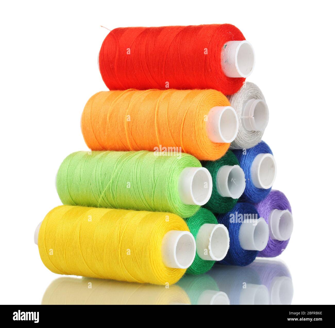 Pyramid of many-coloured bobbins of thread isolated on white Stock ...