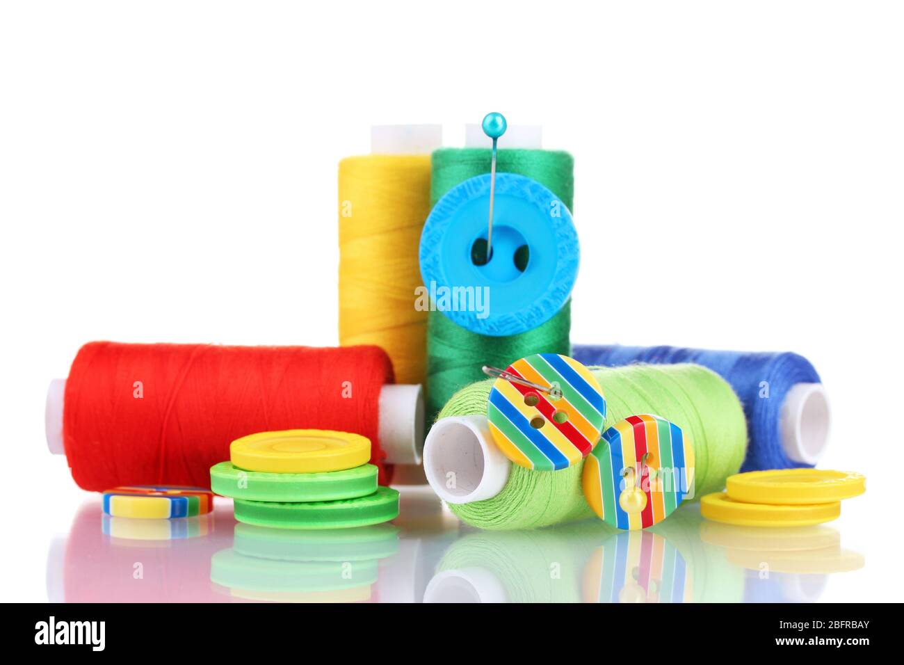 Many bobbin of thread with needle and buttons isolated on white Stock ...