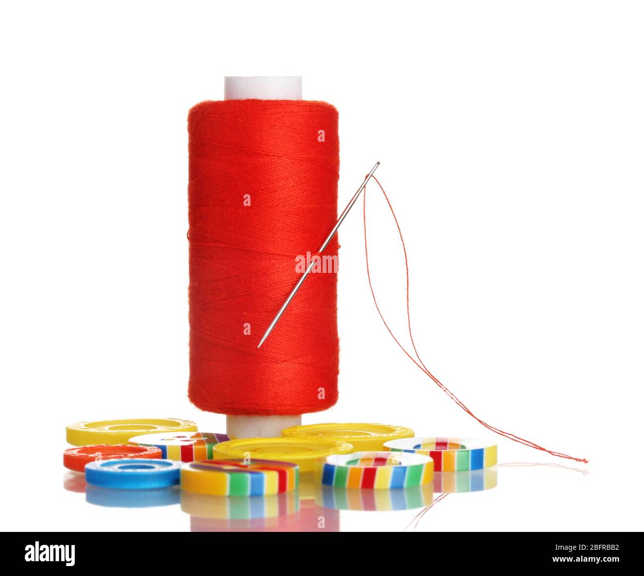 Red bobbin with needle and buttons isolated on white Stock Photo - Alamy