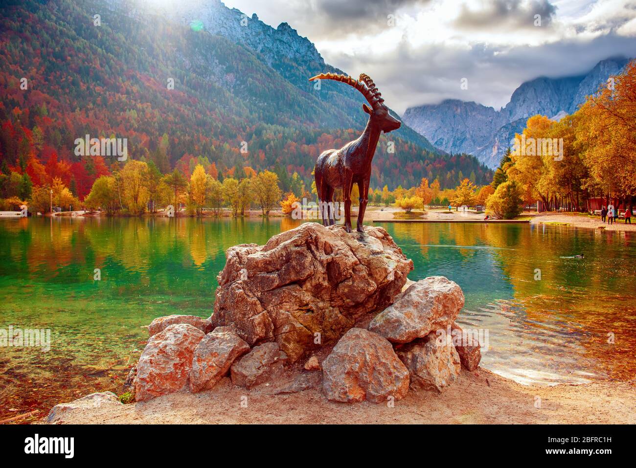 Jasna lake with the monument of the mountain goat - chamois Zlatorog at ...