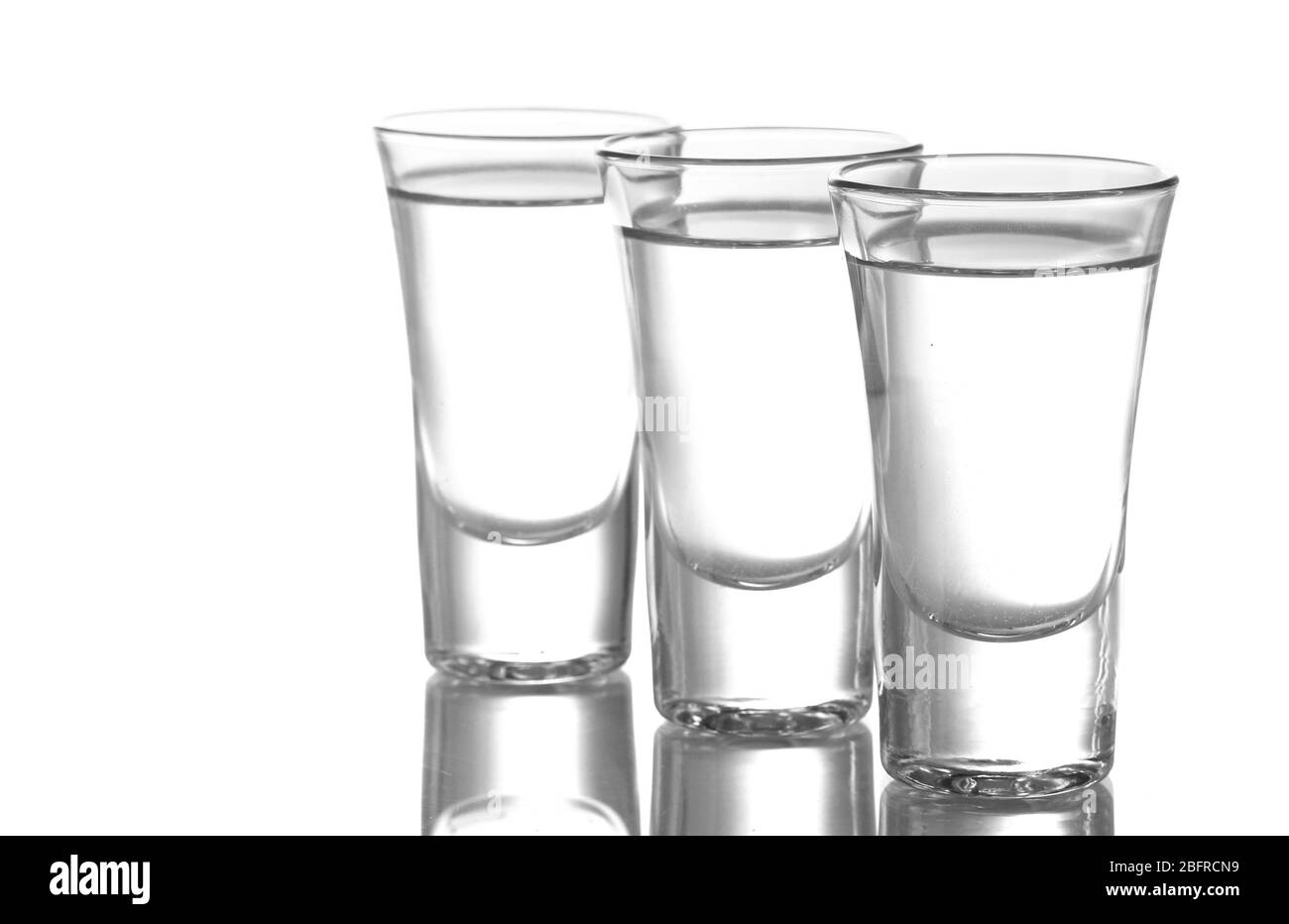 Three glass of vodka isolated on white Stock Photo - Alamy