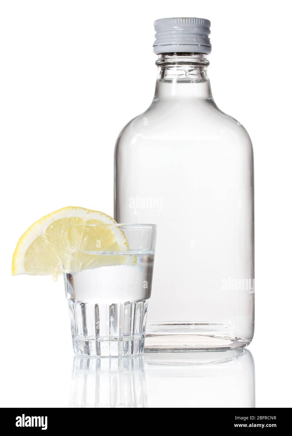 Bottle of vodka and wineglass with lemon isolated on white Stock Photo ...
