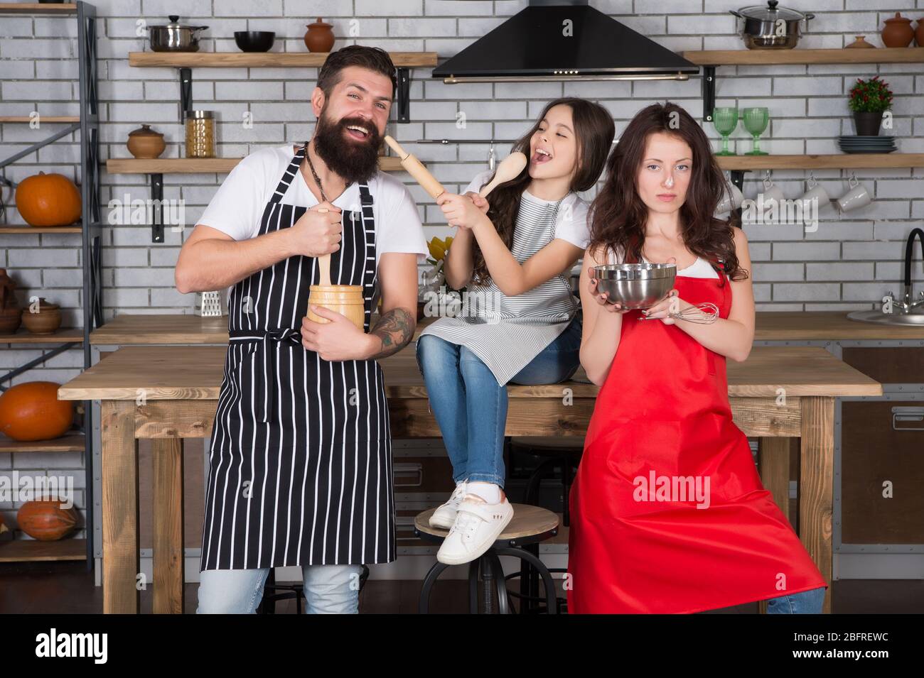 Spending time with family. kid with parents cooking in kitchen at home ...