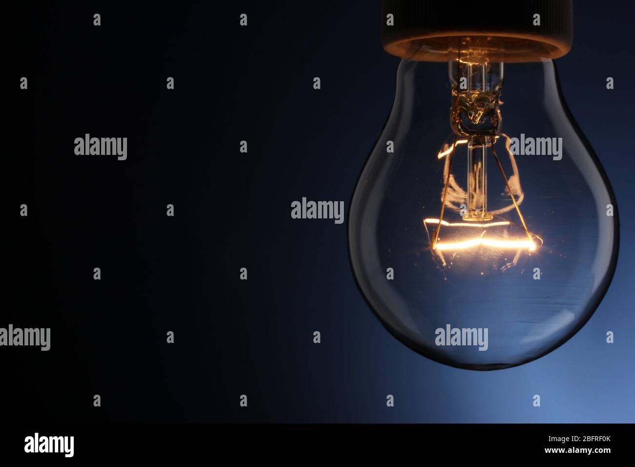 A lit light bulb isolated on white Stock Photo - Alamy