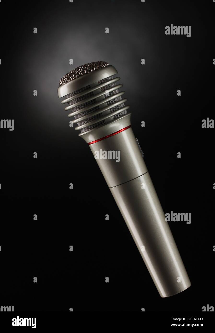 Shiny grey iron microphone on black background Stock Photo - Alamy