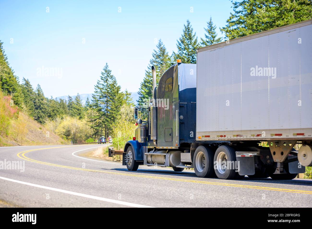 Industrial dark blue big rig classic long haul semi truck with vertical ...
