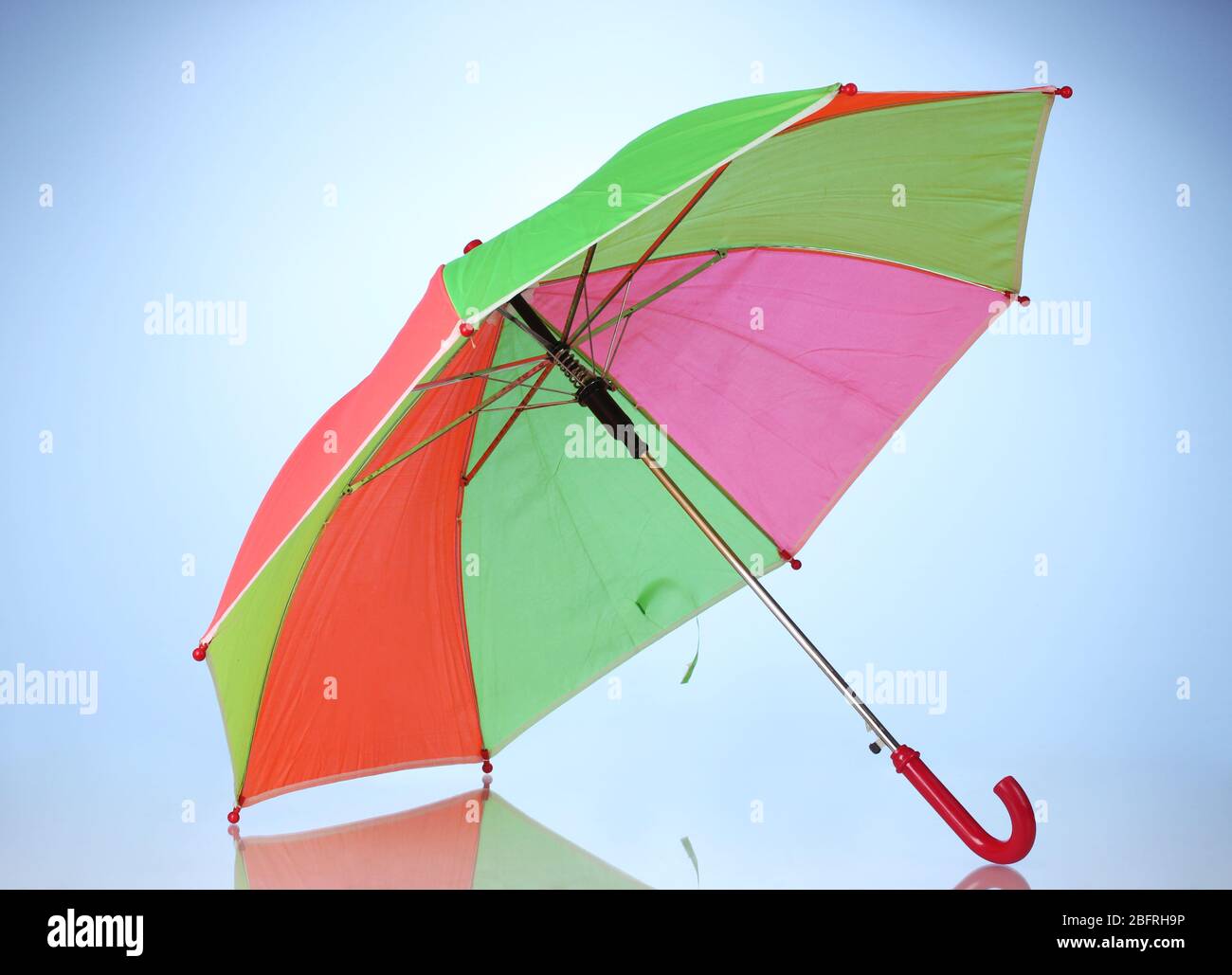 Multi-colored umbrella on blue background Stock Photo - Alamy