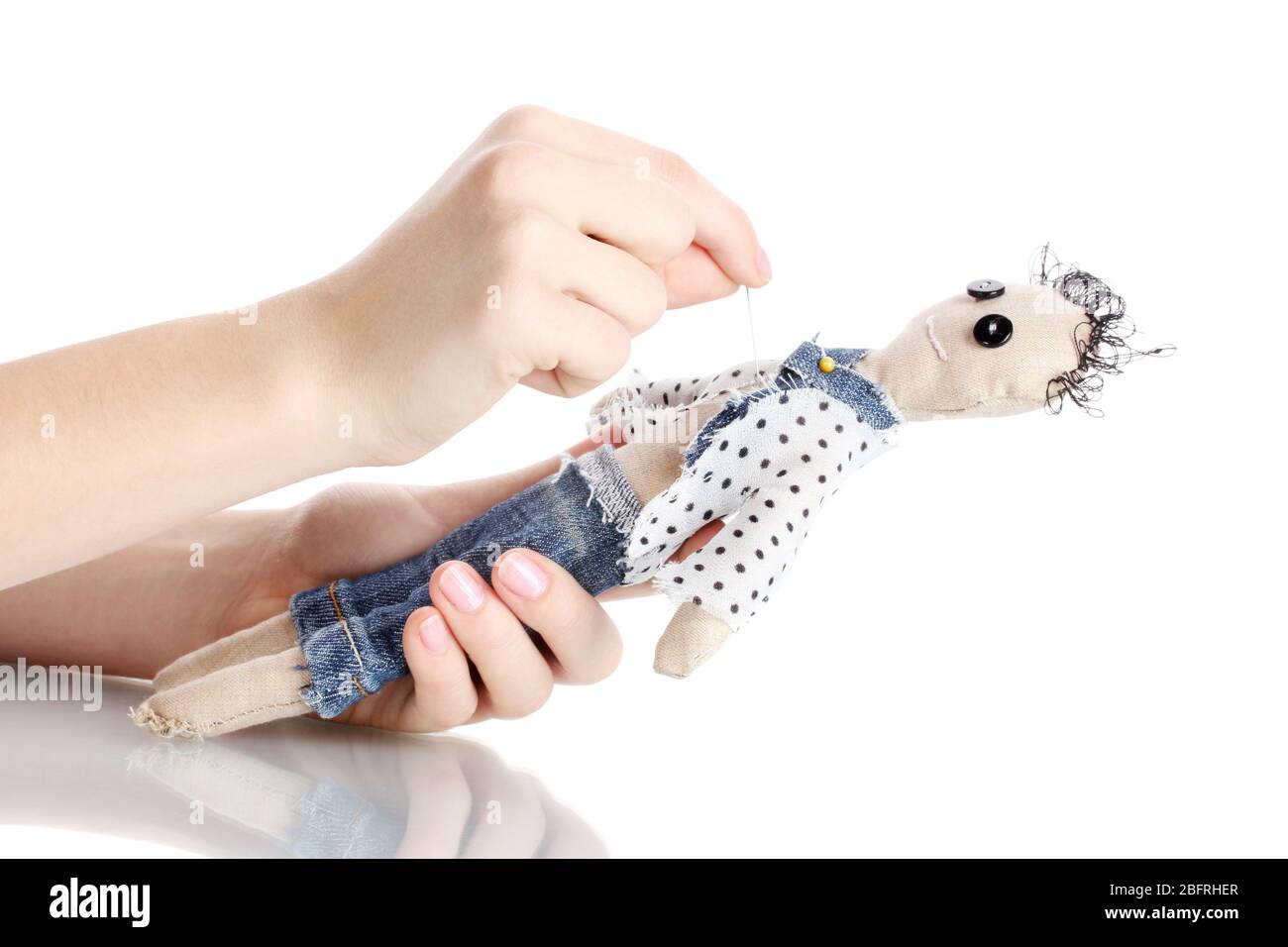Voodoo doll boy in the hands of women isolated on white Stock Photo - Alamy