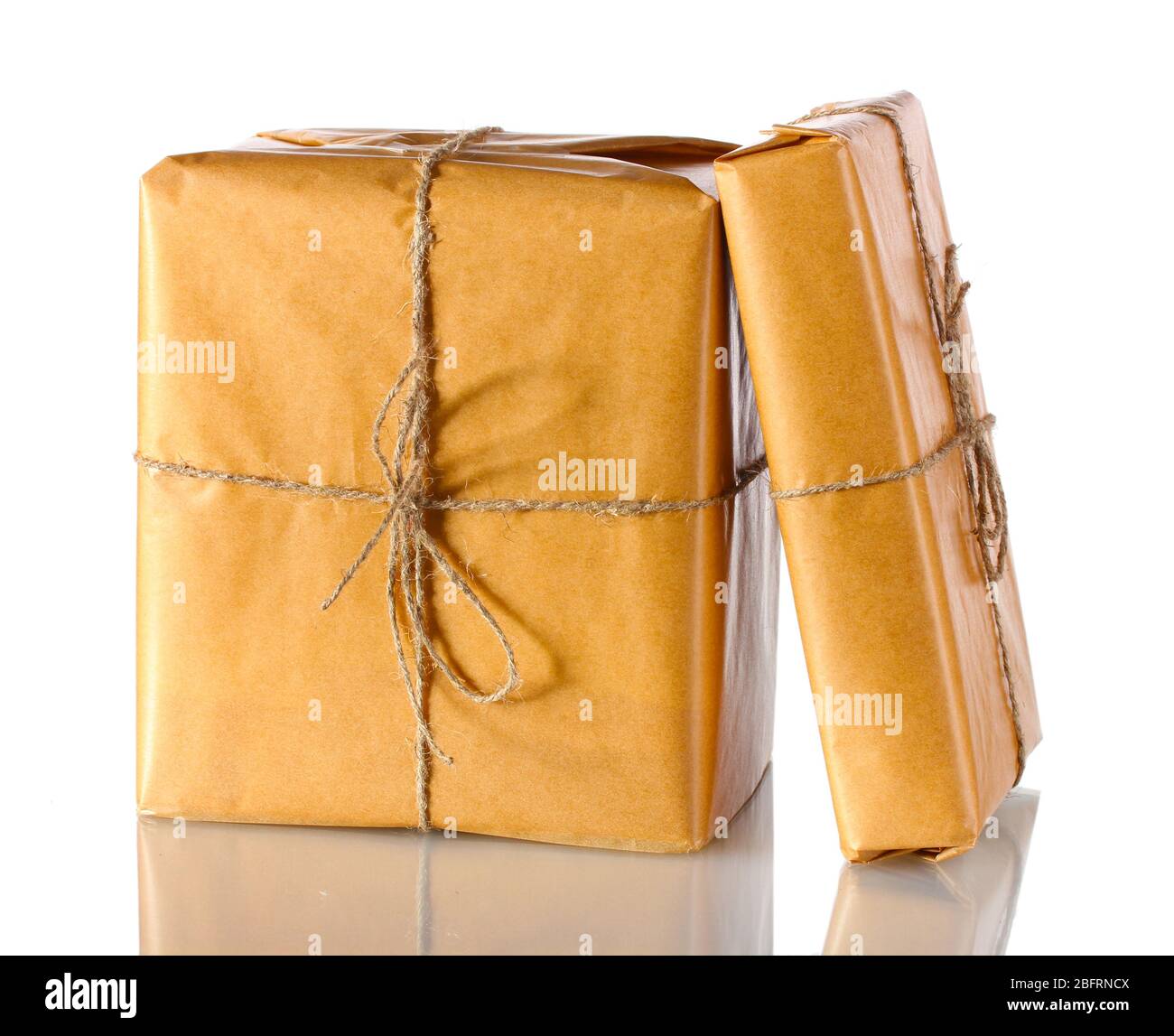 Two parcels wrapped in brown paper tied with twine arranged in stack ...