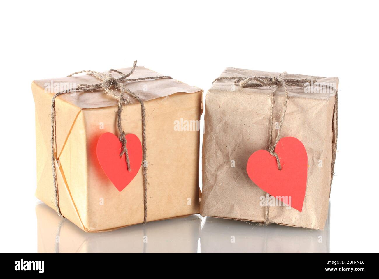 Two small parcels with blank heart-shaped labels isolated on white ...