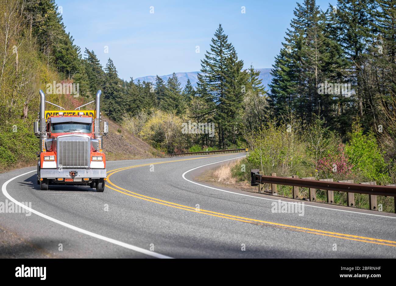 Bonnet big rig orange diesel semi truck with oversize load sign on the ...