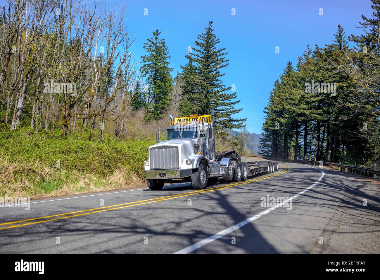 Bonnet big rig white diesel semi truck with oversize load sign on the ...