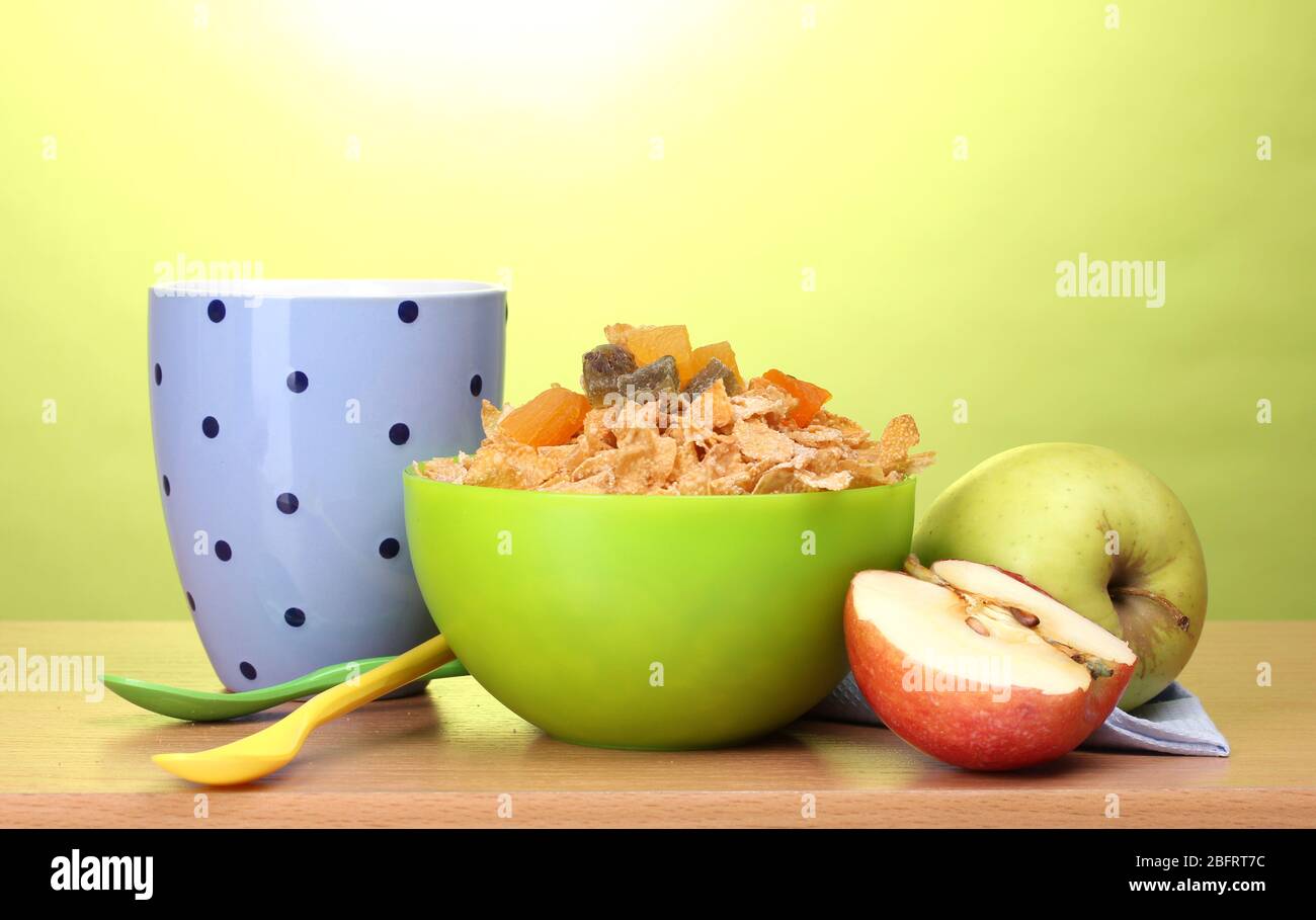 tasty cornflakes in green bowl, apples and glass of milk on wooden ...