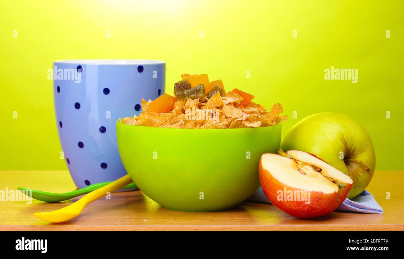 tasty cornflakes in green bowl, apples and glass of milk on wooden ...