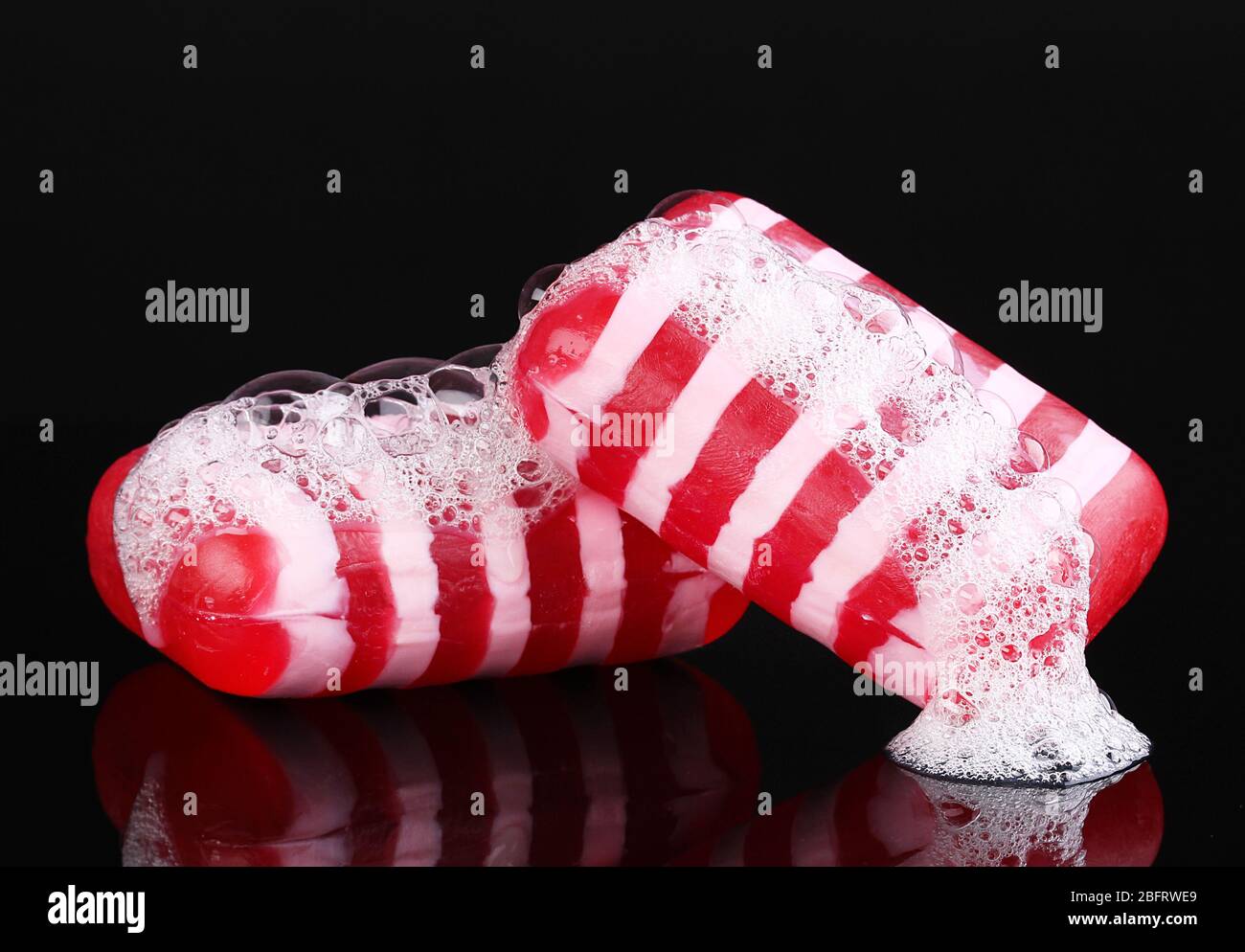 Striped soaps with foam isolated on black Stock Photo - Alamy