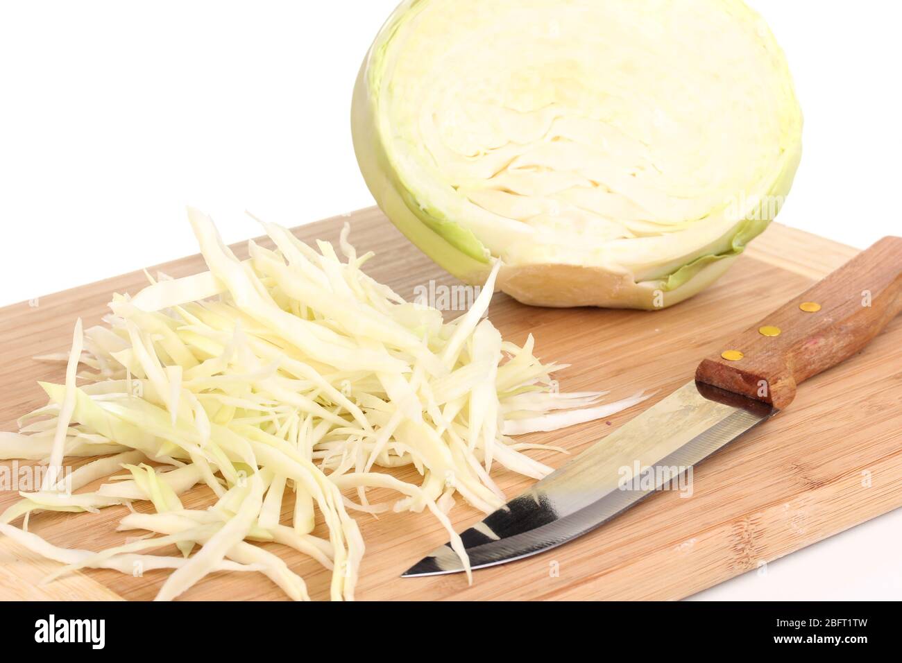 Green cabbage shredded on wooden chopping board close-up isolated on ...