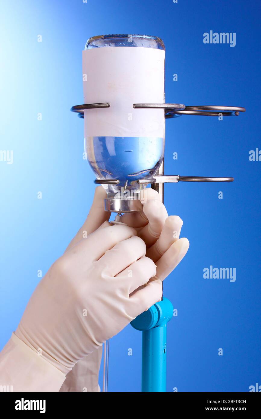 Nurse doing infusion on blue background Stock Photo - Alamy