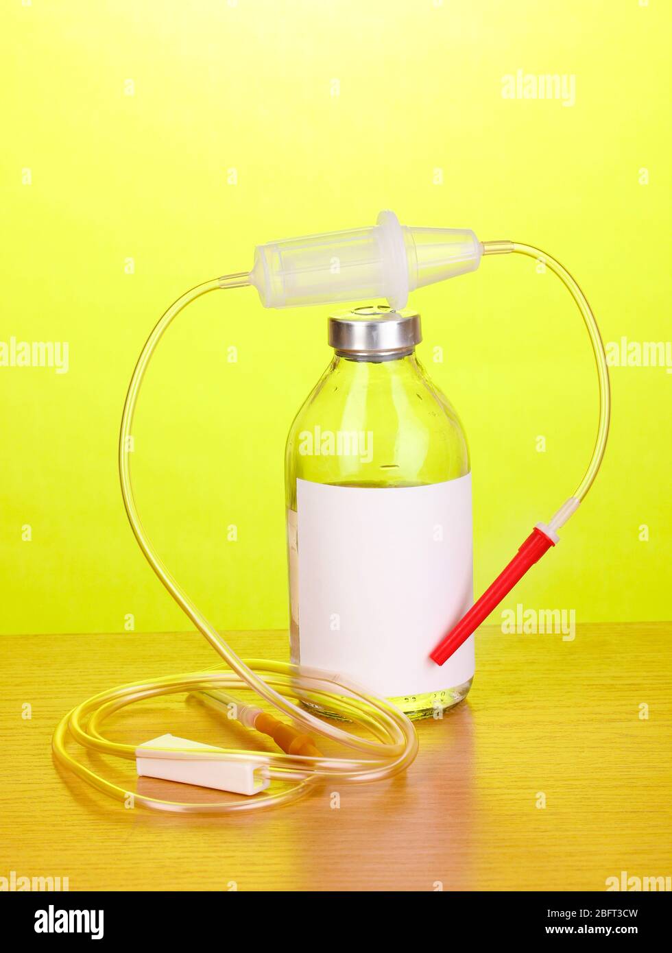 Bottle of intravenous antibiotics and plastic infusion set on wooden ...