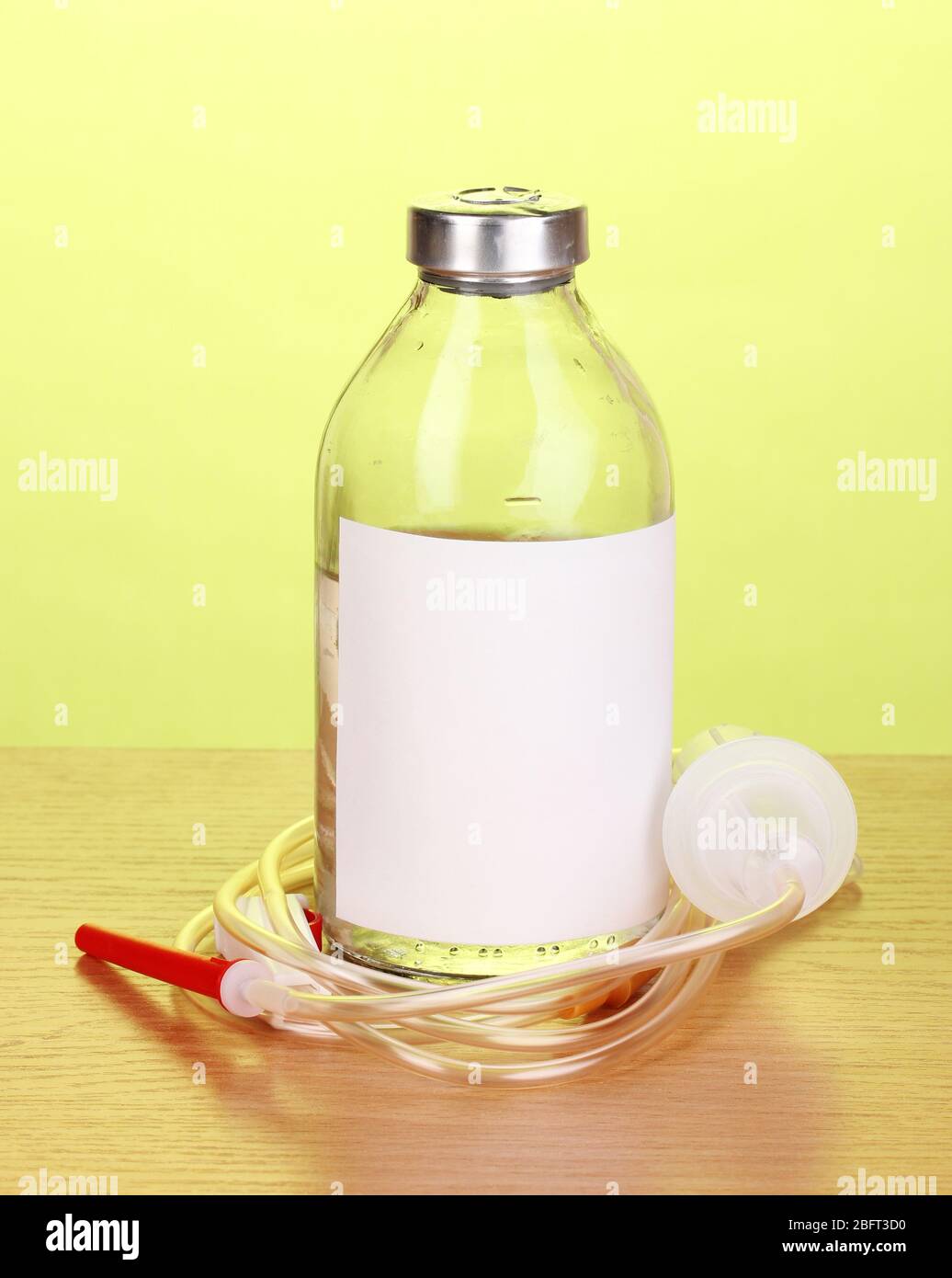 Bottle of intravenous antibiotics and plastic infusion set on wooden ...