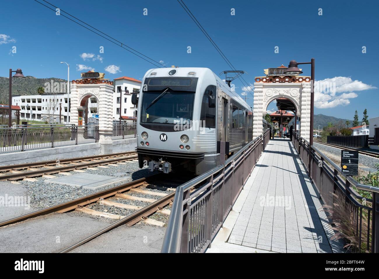 Los Angeles Metro light rail train at the Azusa train station platform on a sunny blue sky day ...