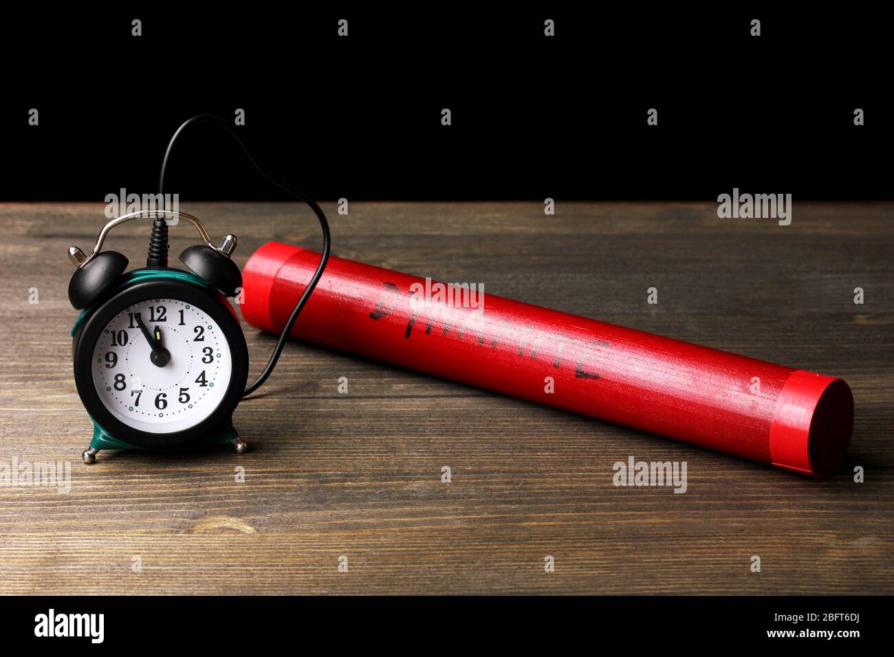 Dynamite with timer on wooden table on black background Stock Photo - Alamy