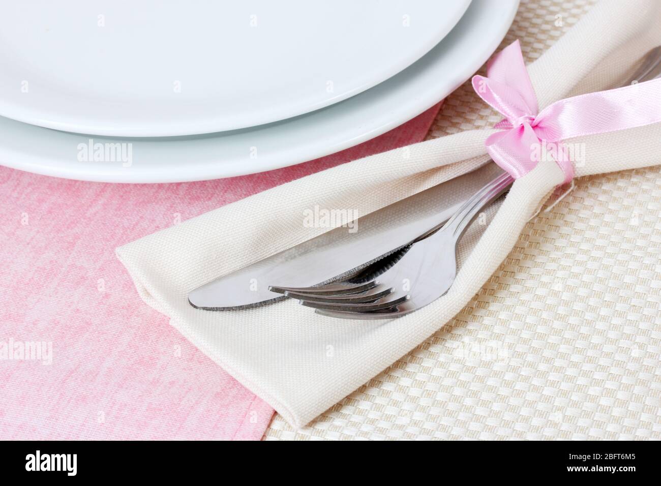 Table setting with fork, knife, plates, and napkin Stock Photo - Alamy