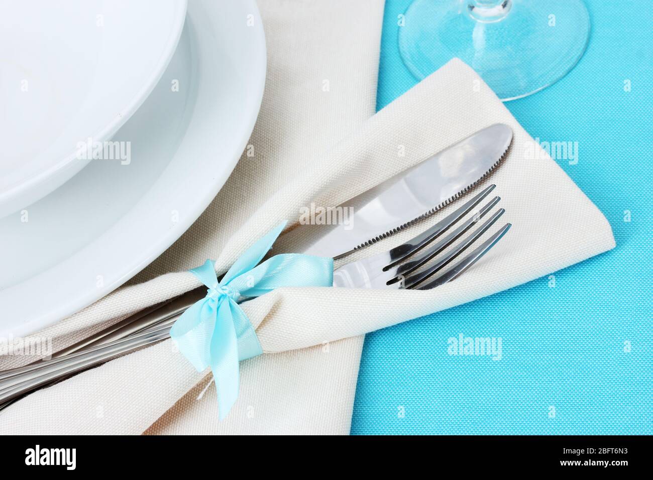 Table setting with fork, knife, plates, and napkin Stock Photo - Alamy