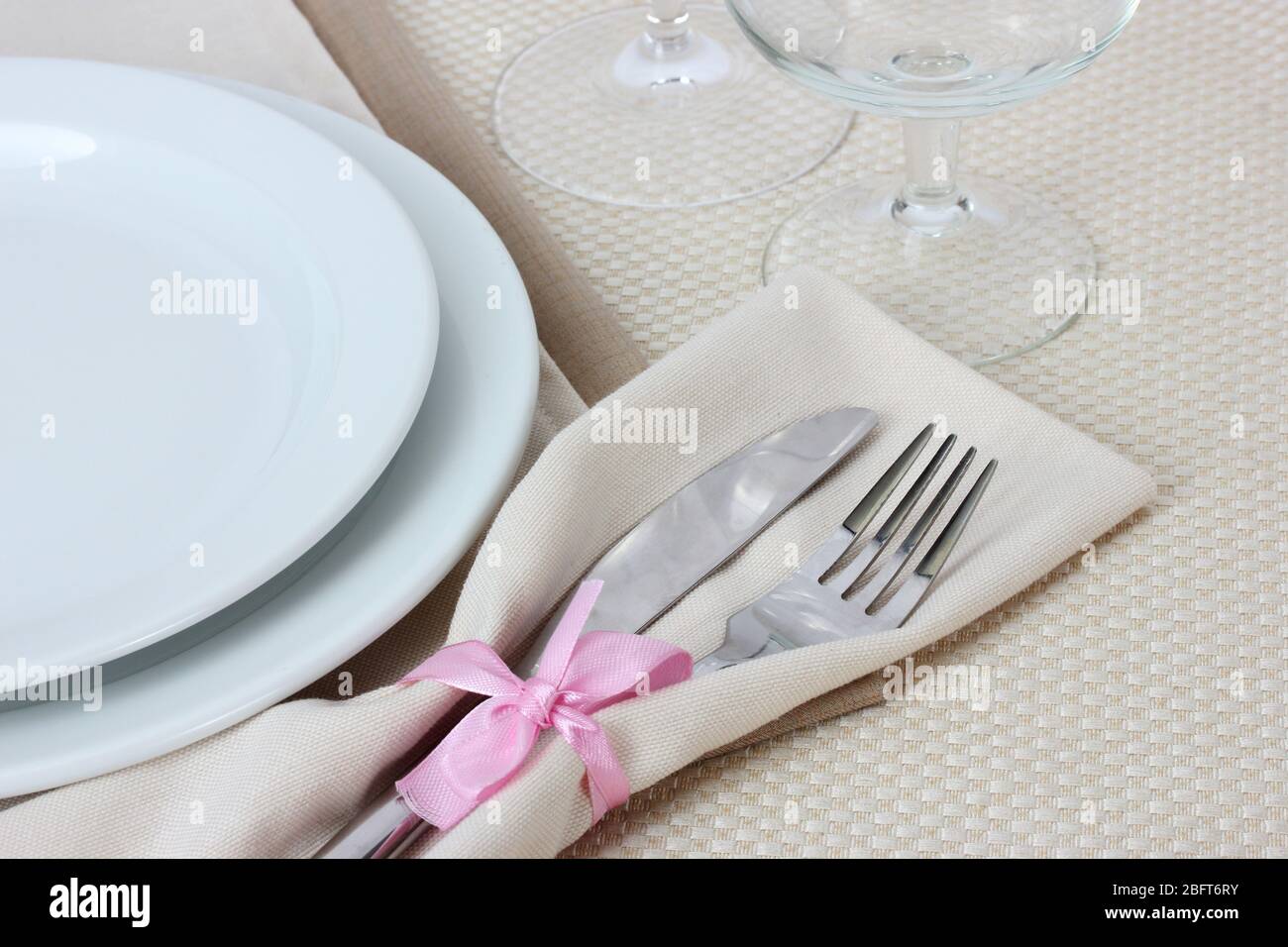 Table setting with fork, knife, plates, and napkin Stock Photo - Alamy