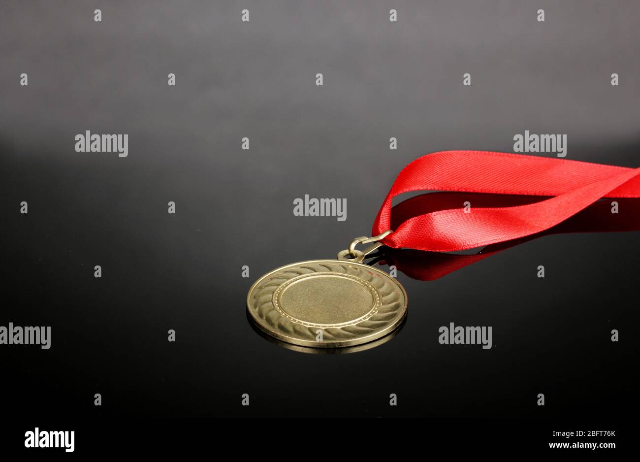Gold medal on grey background Stock Photo - Alamy
