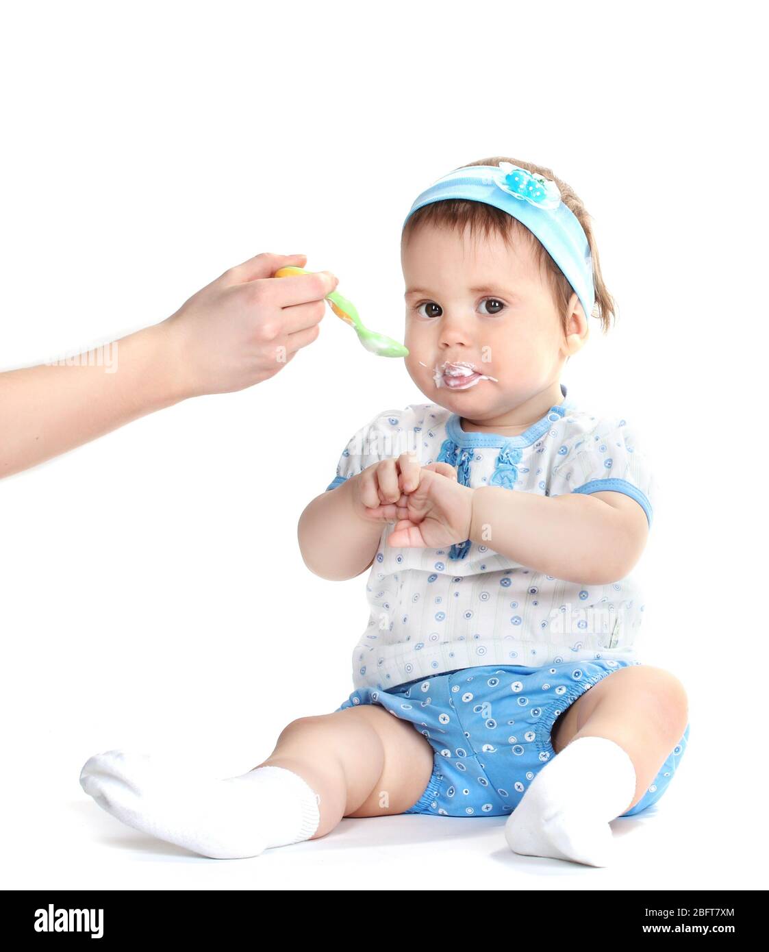 Cute baby girl eating isolated on white Stock Photo - Alamy