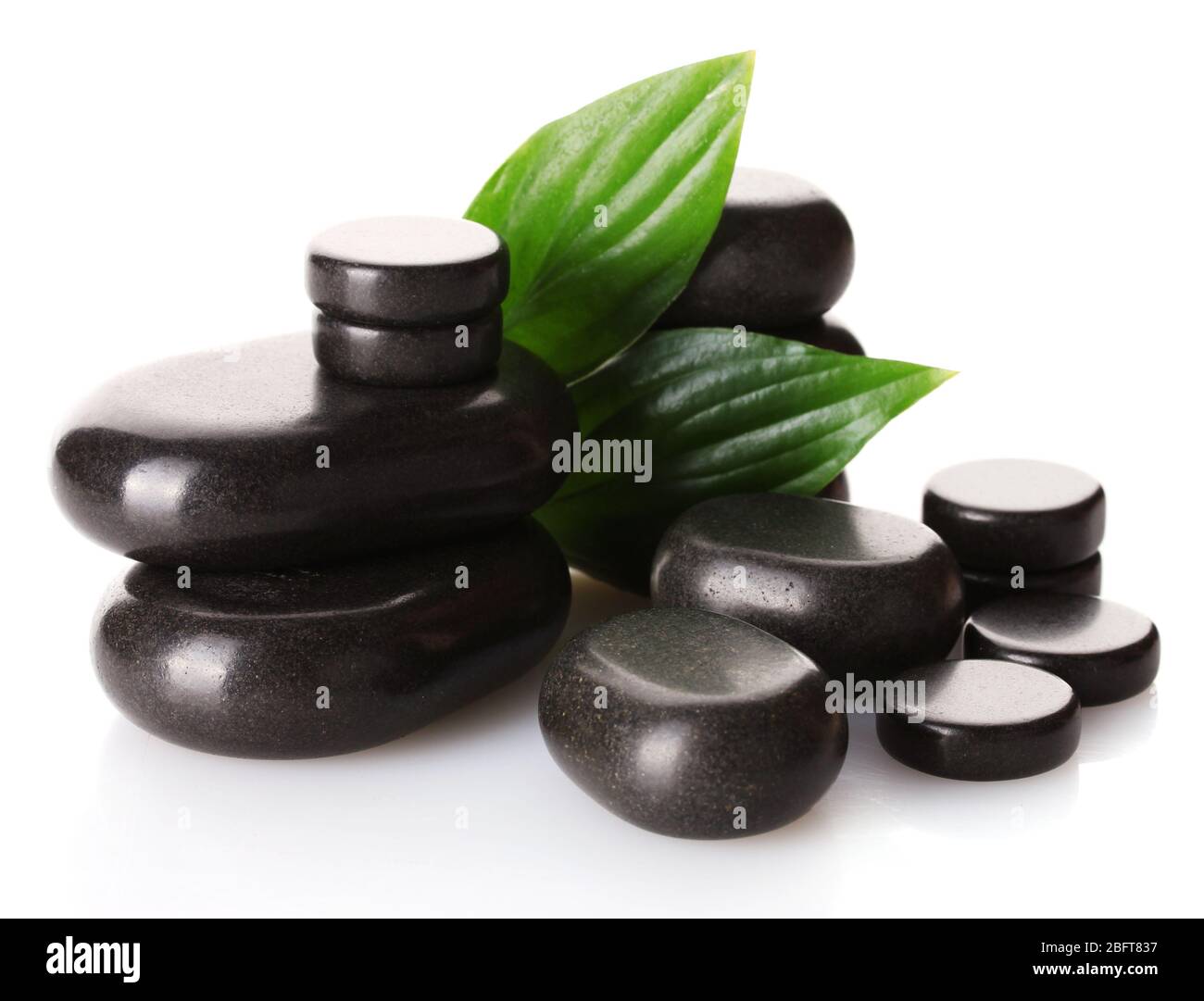 Spa stones and green leaves isolated on white Stock Photo - Alamy