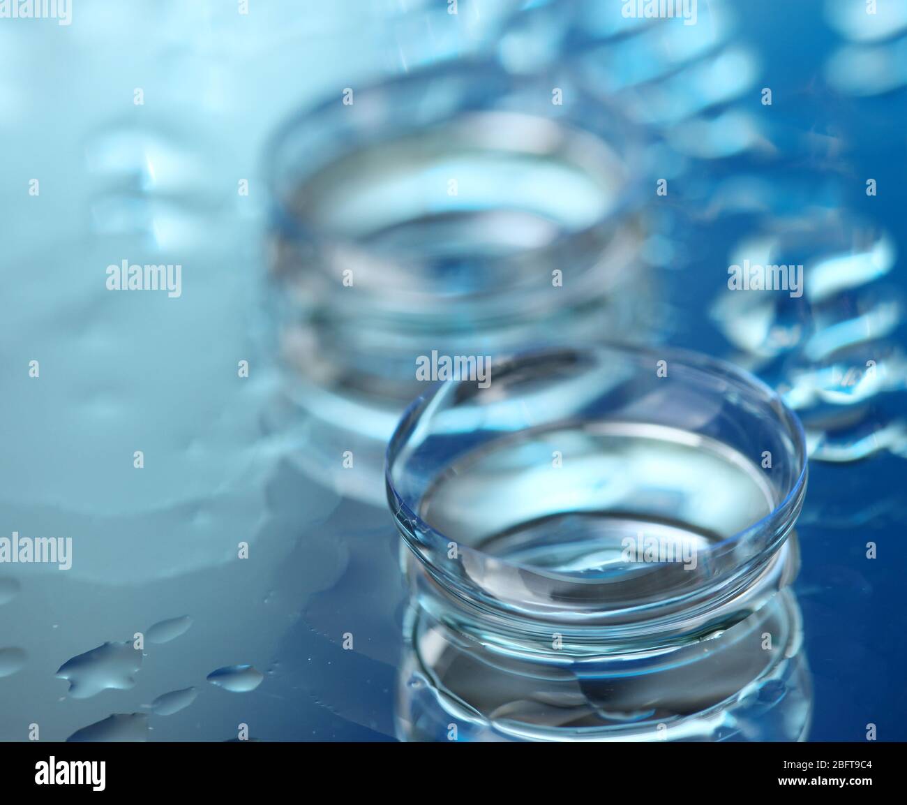 contact lens with drops on blue background Stock Photo - Alamy