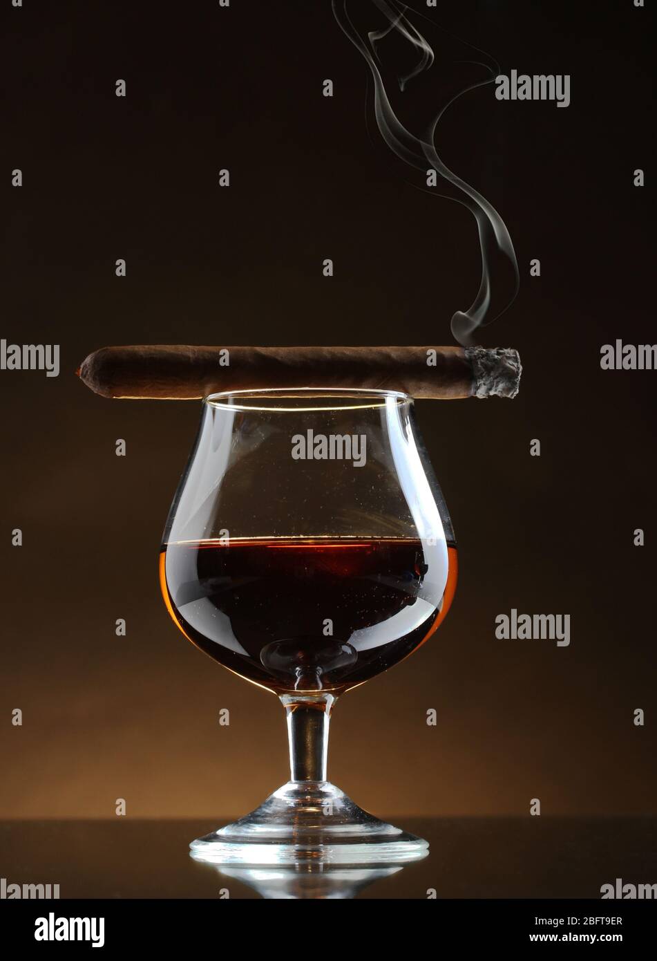 glass of brandy and cigar on brown background Stock Photo - Alamy