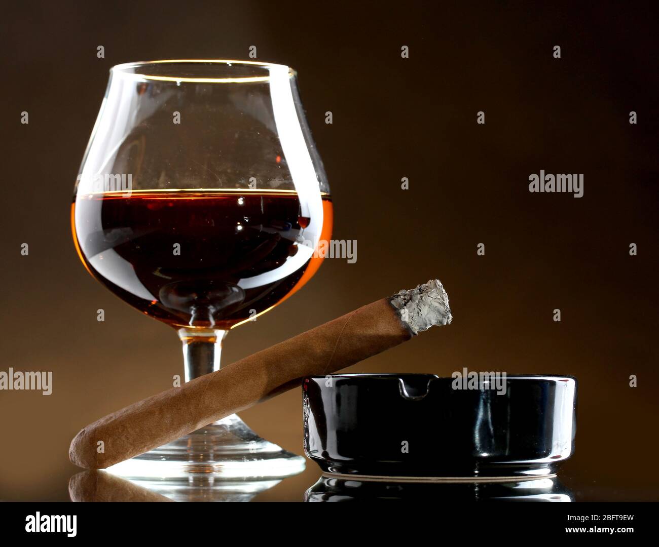 glass of brandy and cigar on brown background Stock Photo - Alamy