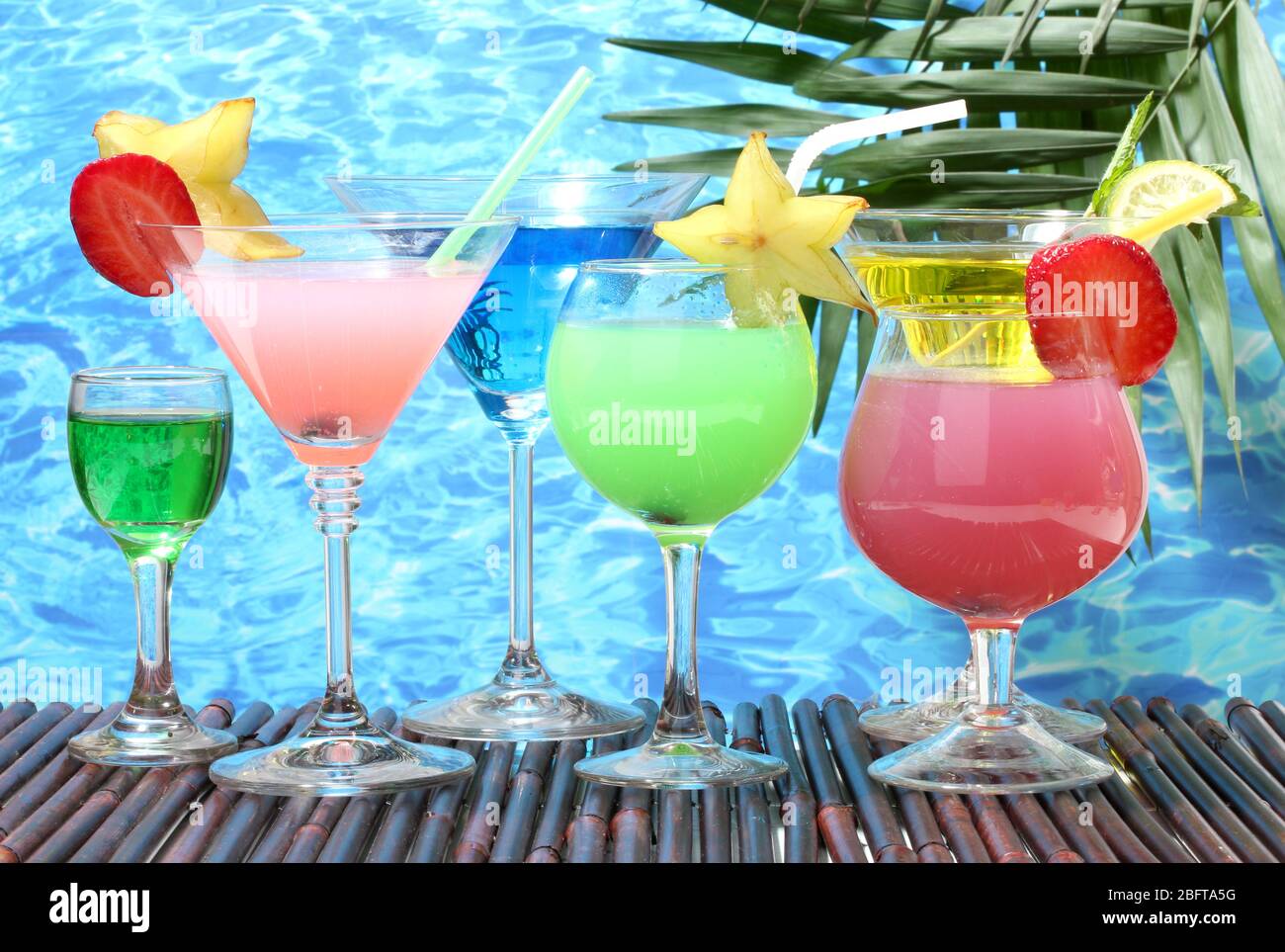 Glasses of cocktails on table on blue sea background Stock Photo - Alamy