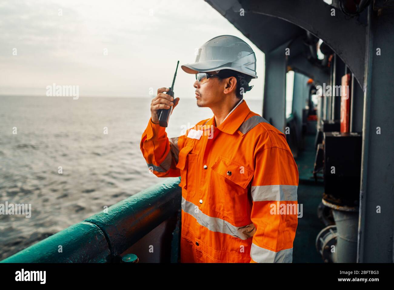 Filipino deck Officer on deck of vessel or ship , wearing PPE personal ...