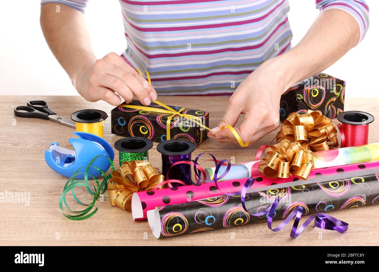 Wrapping presents surrounded by paper, ribbon and bows Stock Photo - Alamy