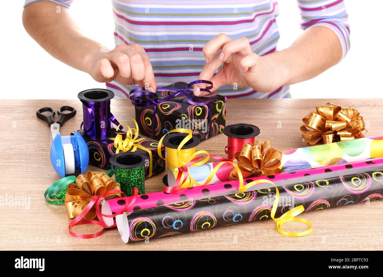 Wrapping presents surrounded by paper, ribbon and bows Stock Photo - Alamy